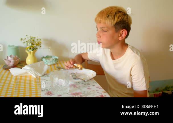 white boy contemplating last bite at floral table setting, small plate ...