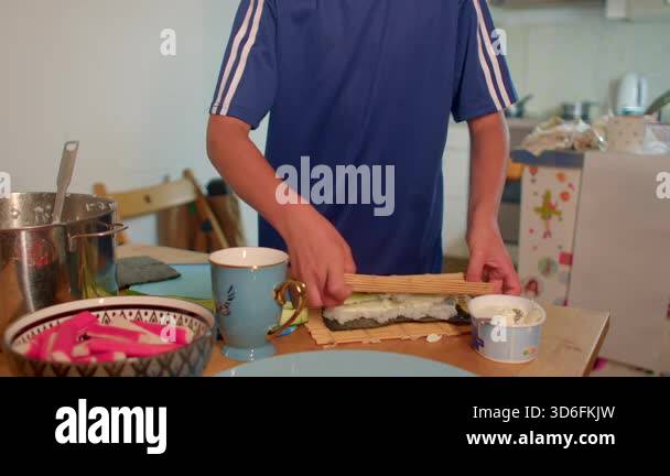 person spreading filling and rolling pastry on kitchen counter with ...