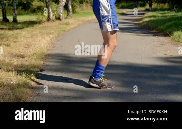 white man walking path with rope in hand, relaxed pace through shaded ...