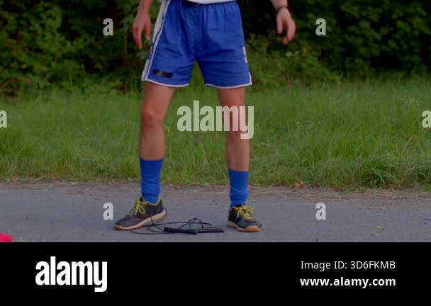 white athlete hamstring stretch before jump rope set roadside grass ...