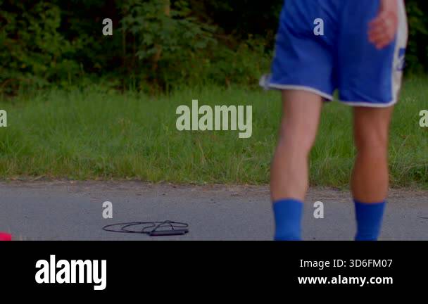 white male setting coiled rope on pavement approaching rope layout ...