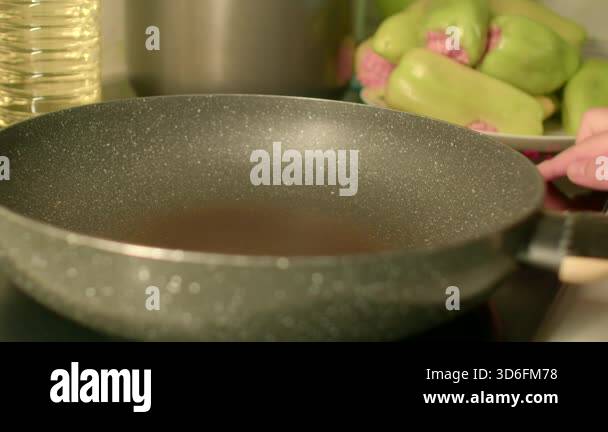 adding oil now, pour oil into hot pan, spilling oil into heated frying ...