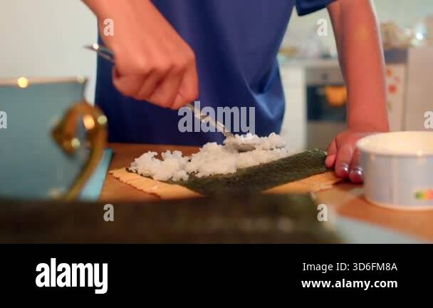 Applying rice uniformly on seaweed surface, Carefully spreading rice ...
