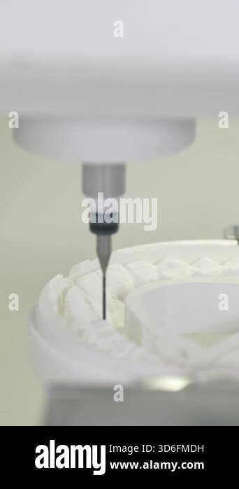CNC system mills dental prosthesis from white disc with spindle ...