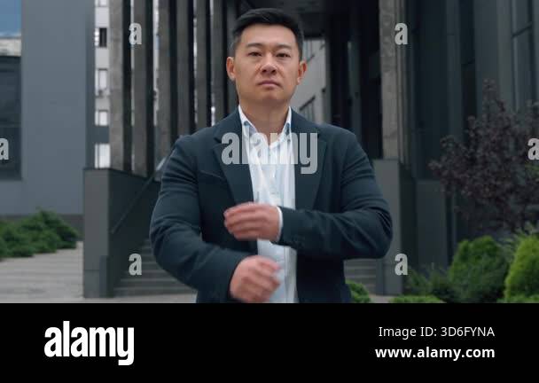 Motivated serious 40s Chinese ethnic business man crossing hands ...