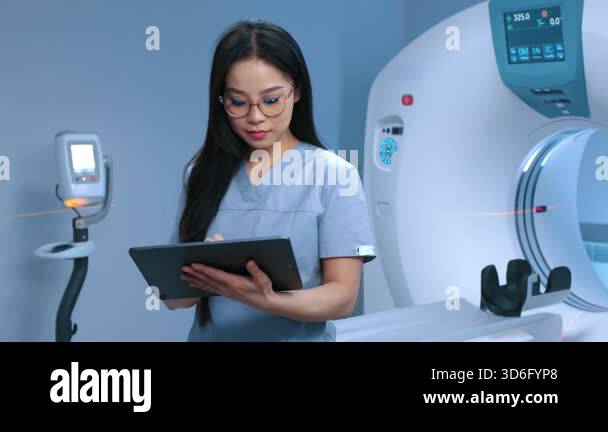 Asian doctor posing at background of magnetic resonance scanner ...