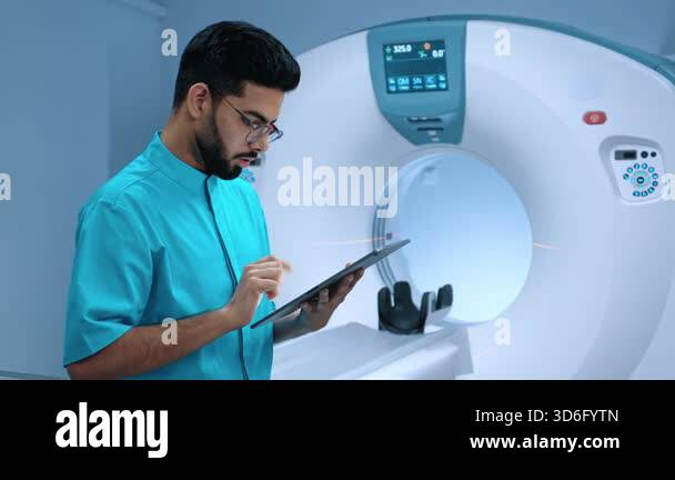 Indian tomography specialist holding tablet. Confident doctor at ...