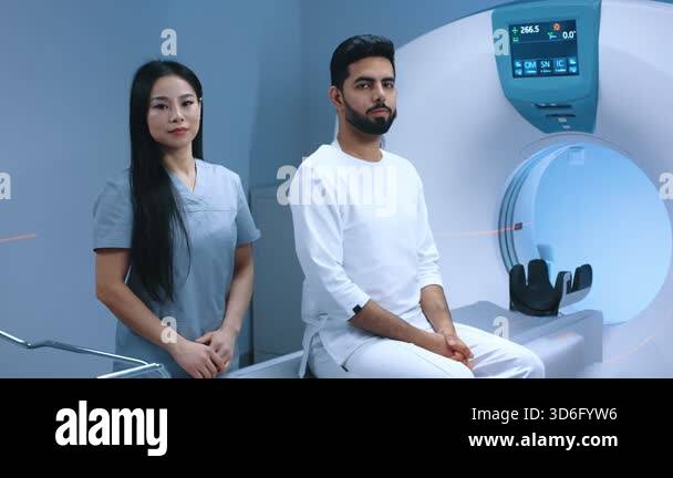 Satisfied doctor and patient looking at camera. Smiling Asian doctor ...