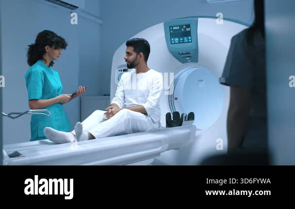 Professional radiologist using tablet, consulting patient before ...