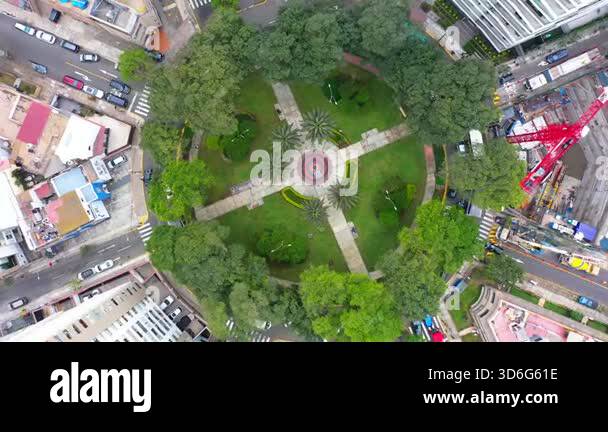 Drone view flying over a circular urban park with lush greenery ...