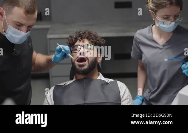 Dentist performs routine checkup with patient in clinic setting ...