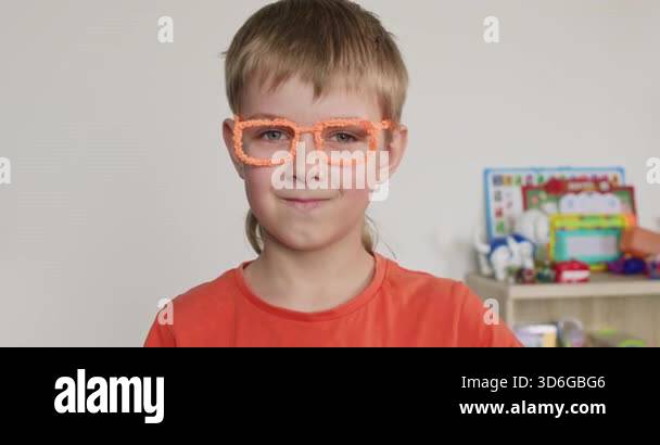 Junior schoolboy wearing plastic glasses frame shows 3d pen filament in ...