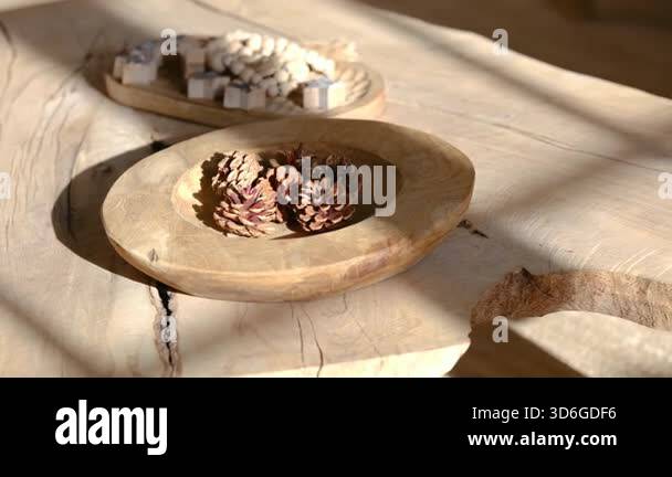 Natural wood bowls with pine cones and dried flowers on a textured ...