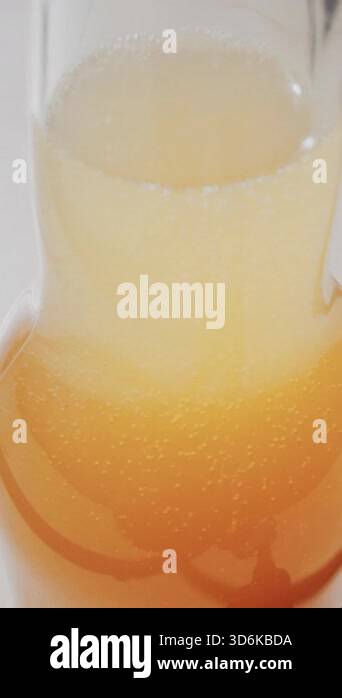 Close up view of fizzy drink with golden bubbles rising inside a glass ...