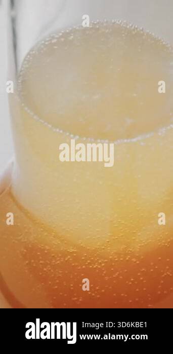 Close up view of fizzy drink with golden bubbles rising inside a glass ...