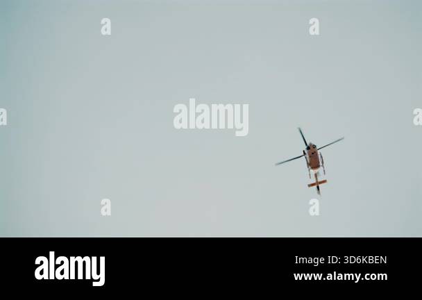 Distant view of a helicopter flying alone against a pale sky Stock ...