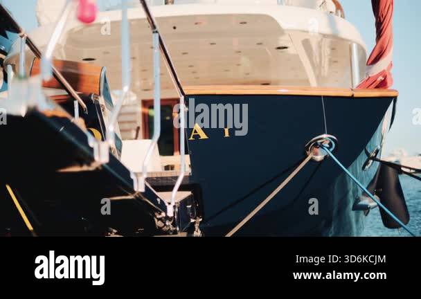 Rear angle of a luxury blue yacht with wooden details docked in a ...