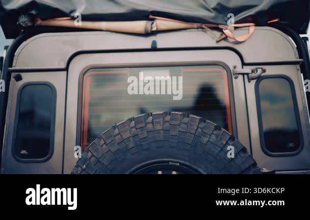 Back view of an off road vehicle equipped with spare tire and roof tent ...
