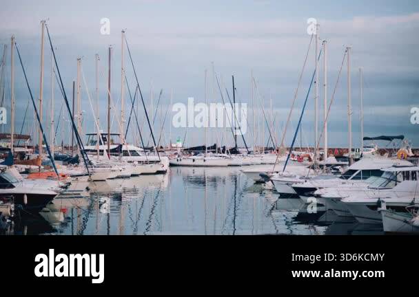 Wide view of a marina full of yachts and sailboats under a soft morning ...