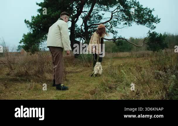 A dynamic handheld tracking shot follows a happy, playful young couple ...