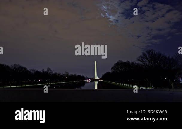 The full moon is seen through clouds over the Washington Monument and U ...