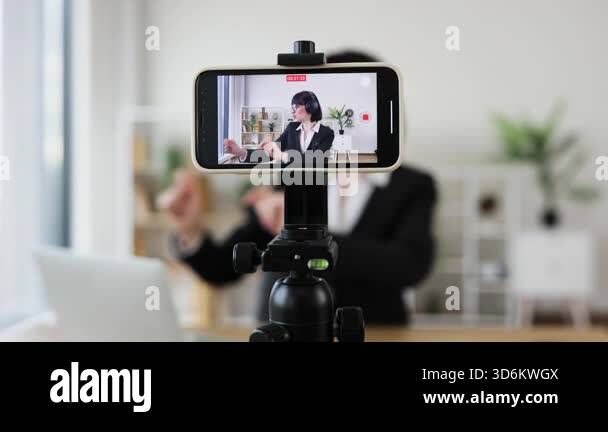 Caucasian woman sitting at table filming a video blog about relaxation ...