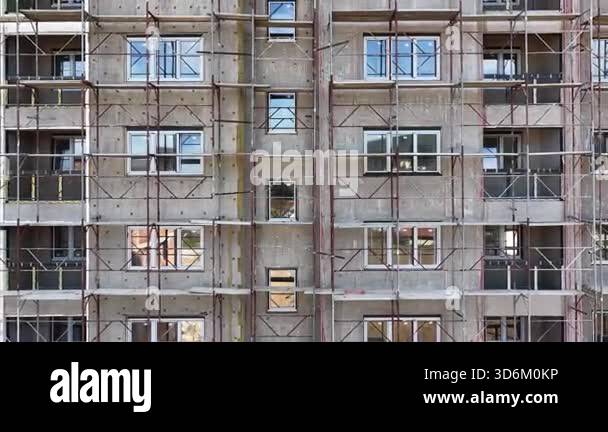 Aerial drone video slowly pulling back from apartment building facade ...