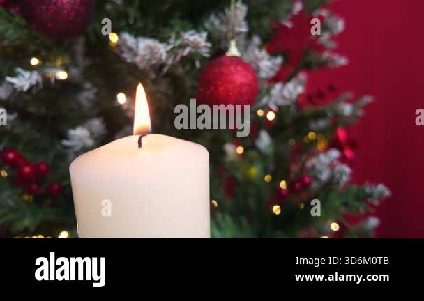 Slow motion camera move to the left showing a burning candle in front ...