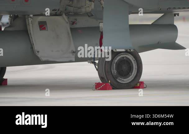Side view of military aircraft main landing gear with wheel secured by ...