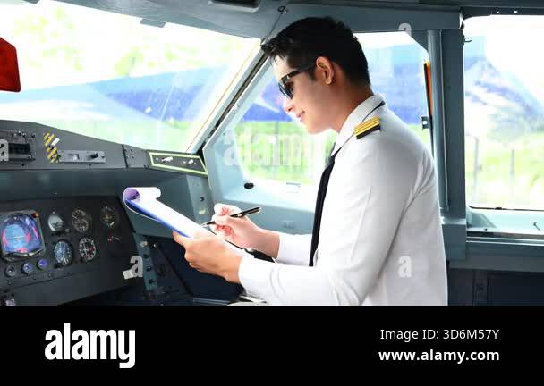 Pilot writing notes inside airplane cockpit wearing sunglasses Stock ...