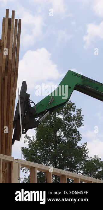 Workers are assembling structure with telehandler crane lifting wooden ...