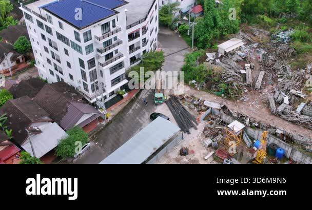 Aerial view of a construction site where a worker on the ground guides ...
