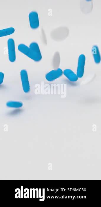 Blue and white tablets falling on white background in slow motion ...
