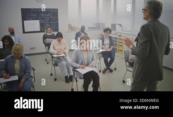 Adult Learners Sitting at Desks, Concentrated on Test or Exercise ...