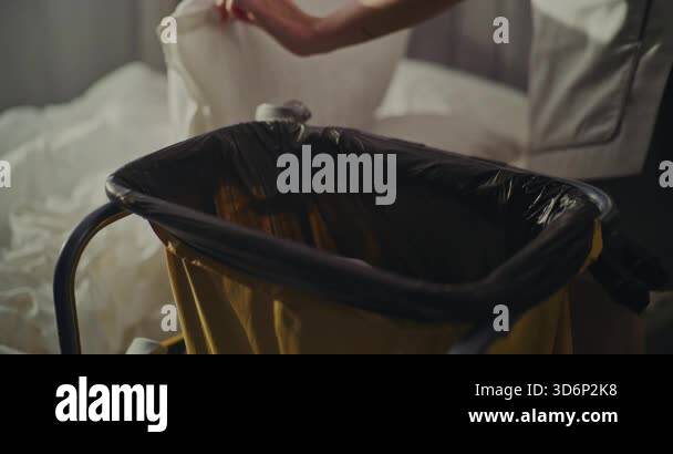 Close Up of Maid in Hotel Suite Folds and Collects Used Linens, Placing ...