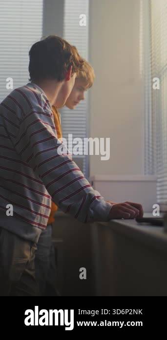 Two Teenage Boys Stand Together Near Sunlit Classroom Window, Talking ...