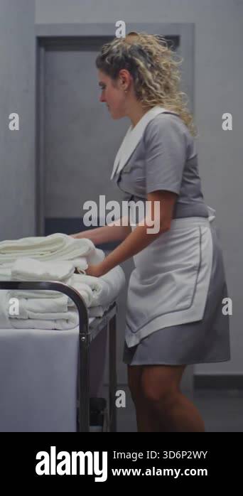 Female Maid in Professional Uniform Moves Cleaning Trolley Down Hallway ...