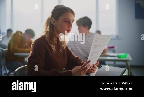 Young Female Student Smiles Brightly as Examines A Grade Report or ...