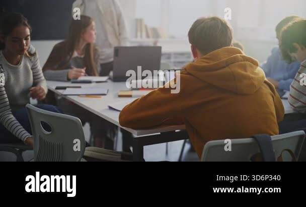 Group of Students Gathered Around Shared Workspace, Actively ...