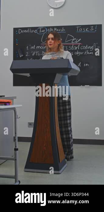 Young Woman Speaks Confidently at Podium, Smiling While Addressing ...
