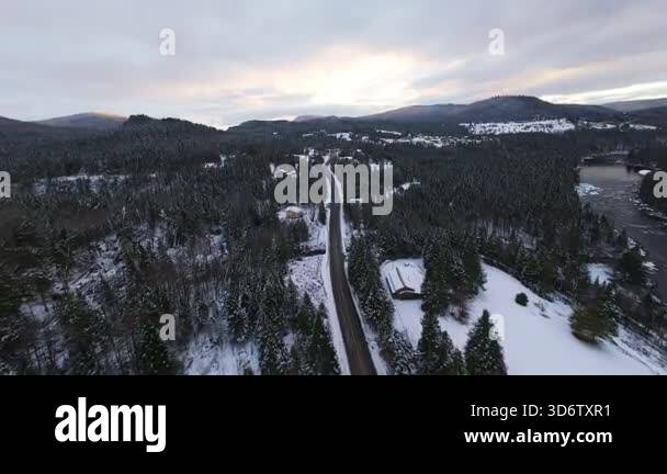 Aerial pass through a snowy ravine with strong contrast between shadows ...
