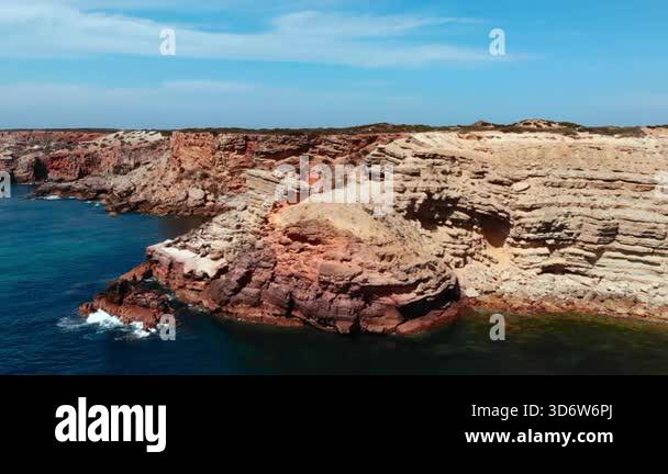 aerial layered sandstone cliffs with red ochre bands cinematic drone ...
