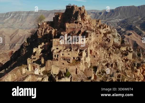 brave hiker overlooks cliffside fortress ruins, person in red jacket ...