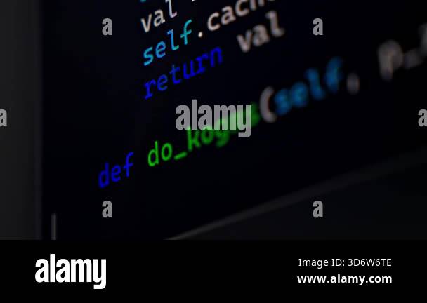 Closeup view of a computer monitor showing programming code on a dark ...