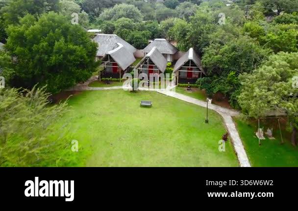 riverside cottage cluster with lawn aerial view of three thatched ...