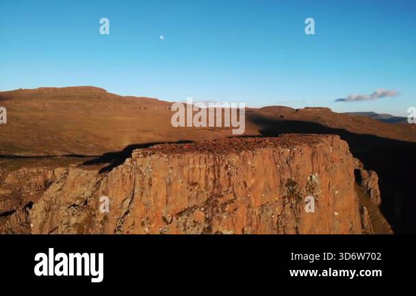 plateau cliff at daylight, field geologist examines sparse grassland ...