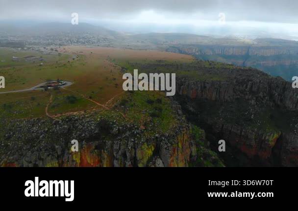misty moorland plateau above deep gorge with winding path and low ...