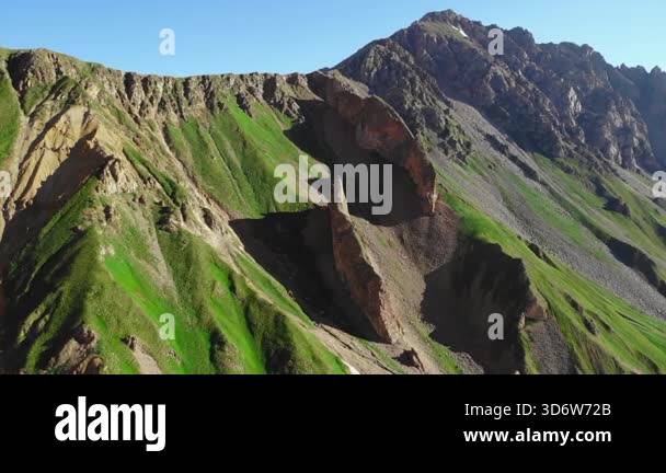 aerial eroded crater ridge panorama with steep talus slopes and layered ...