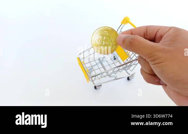 hand inserts token Bitcoin into a small shopping cart symbolizing ...