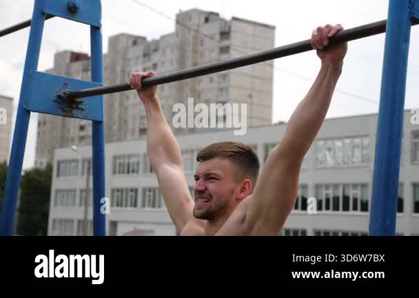 Sportsman performing a dynamic pull-up workout, showcasing strength and ...